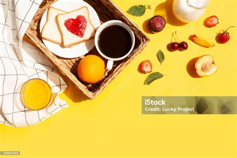 오렌지 주스 커피 한 잔 하트 모양의 잼 샌드위치 딸기로 구성된 로맨틱한 아침 식사 대비를 이루는 그림자 트렌드 플랫 레이