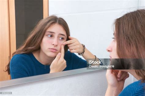 아름 다운 십 대 소녀 거울 그녀 발견된 여드름 문제 전에 그녀의 얼굴을 만지고 목욕탕에서 서 그리고 거울에 있는 그녀의 반영을 보고 가정 생활에 대한 스톡 사진 및 기타