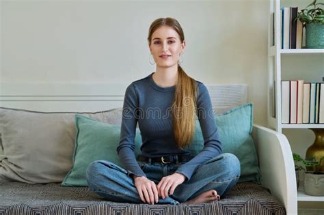 Portrait Relaxed Teenage Girl Sitting In Lotus Position On Couch At
