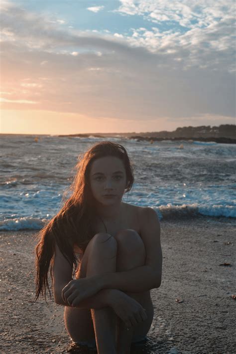 Topless Woman Sitting On Beach During Sunset Photo Free Beach Image