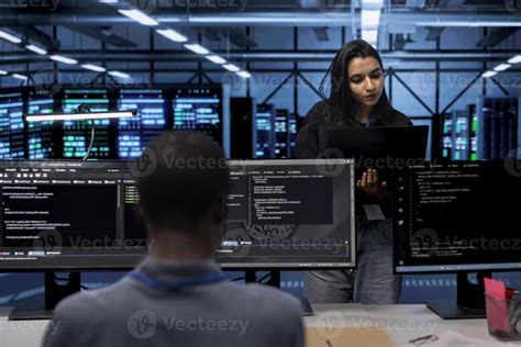 computer scientists in data center running system diagnostic tests on laptop to fix problems it