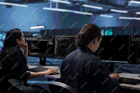 Premium Photo Admins In Data Center Typing On Computers Fixing Errors