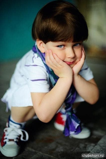 Маленький мальчик сидит на корточках Шорты фото