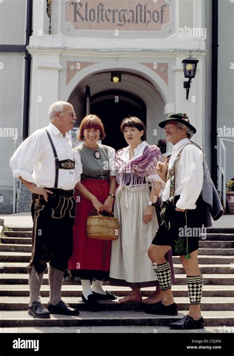 Group Of Four Bavarians In Traditional Costume Standing On Steps Of