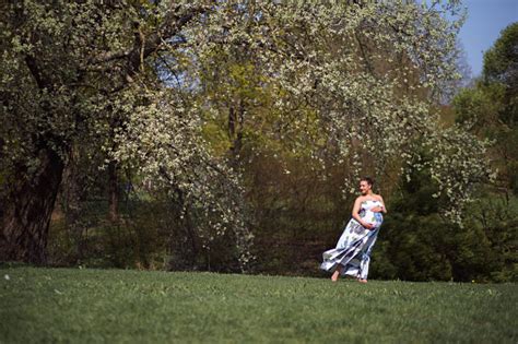 젊은 여행자 임신 한 여자 걷기 달리기 주위를 선회 하 고 꽃 패턴으로 여름 빛 긴 드레스를 입고 꽃 피는 사쿠라 벚꽃 나무 공원에서 그녀의 여가 자유 시간을 즐긴다 개념에