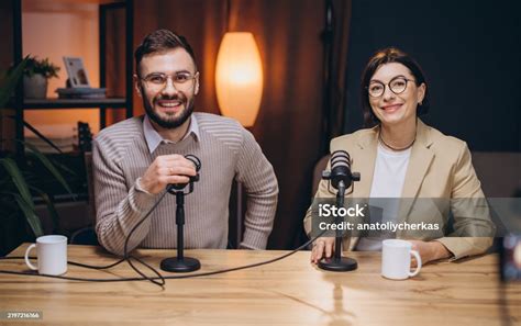 전문 스튜디오 환경에서 오디오 콘텐츠를 녹음하면서 활발한 대화를 나누는 두 명의 미소 짓는 팟캐스터 2명에 대한 스톡 사진 및 기타 이미지 Istock