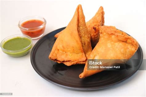 채식주의 알루 사모사 또는 사모사 인도의 특별한 전통 거리 음식 매운 삶은 감자 혼합물로 가득 찬 유명한 인도 펀자비 사모사 녹색과 빨간색 처트니와 함께 제공됩니다 공간을