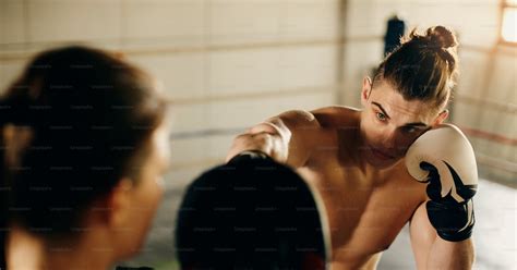 권투 링에서 강사와 함께 운동하는 젊은 근육질의 권투 선수 사진 Unsplash의 운동 이미지