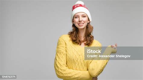 고립 된 배경을 가진 스튜디오에서 크리스마스 여성 초상화 여자는 빨간 산타 클로스 모자를 착용 복사 공간이 있는 개념입니다 행복한 소녀는 포즈를 취하고 카메라를 몸짓을합니다