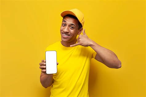제복을 입은 배달 서비스 직원이 컬러 배경에 전화기 화면을 보여주고 스마트폰을 들고 있는 아프리카계 미국인 남성 남자에 대한 스톡 사진 및 기타 이미지 Istock