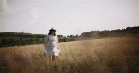 산속의 햇살이 내리쬐는 초원에 있는 허브와 야생화 린넨 드레스를 입은 소녀의 흐릿한 이미지가 걷고 있다 시골에서 휴식을 취하는 보헤미안 여자 소박한 생활 스타일 대기