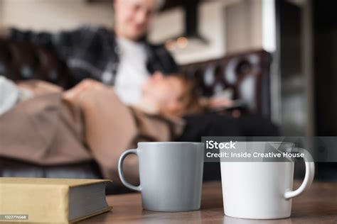 커피 테이블에 책과 두 젊은 연인배경과 두 차 머그잔 컵의 이미지를 가까이 에 초점을 맞추고 함께 시간을 보내고 사랑과 열정