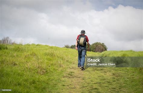 폭풍우가 몰아치는 흐린 하늘 아래 오르막길을 걷는 남자 롱 베이 해안 산책로 오클랜드 60 64세에 대한 스톡 사진 및 기타 이미지 60 64세 개념 건강한 생활방식