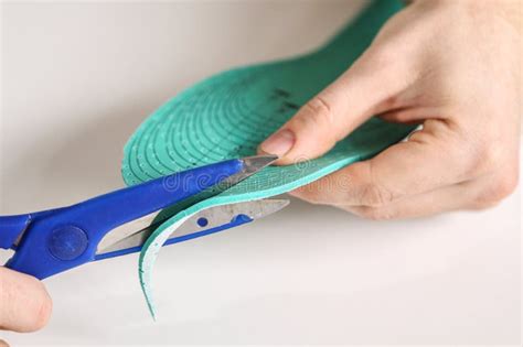 Man Cuts Out New Shoe Insoles With Scissors To Fit His Foot Size Stock