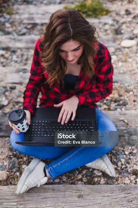 캐주얼 한 옷을 입고 노트북과 함께 철도에 앉아 커피 한 잔을 들고 젊은 아름다운 여자의 상단보기 아웃 도어 라이프 스타일 여행 개념 개념에 대한 스톡 사진 및 기타 이미지