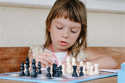 Focused Girl Playing Chess By Stocksy Contributor Olga Sibirskaya Stocksy