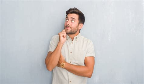 회색 그런 지 위에 잘생긴 젊은 남자 턱 질문 잠겨있는 표현에 대 한 생각에 손와 여름 셔츠를 입고 벽 사려깊은 얼굴 미소 의심 개념입니다 남자에 대한 스톡 사진 및 기타