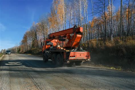 트럭 크레인은 화려한 나무와 푸른 하늘의 배경에 대한 숲 길을 따라 타고 강철에 대한 스톡 사진 및 기타 이미지 강철 개발 건설 기계류 Istock