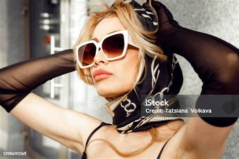 검은 드레스 긴 메쉬 장갑 실크 인쇄 스카프를 입은 긴 물결 모양의 공정한 머리를 가진 젊은 화려한 여성의 초상화 패션에 대한