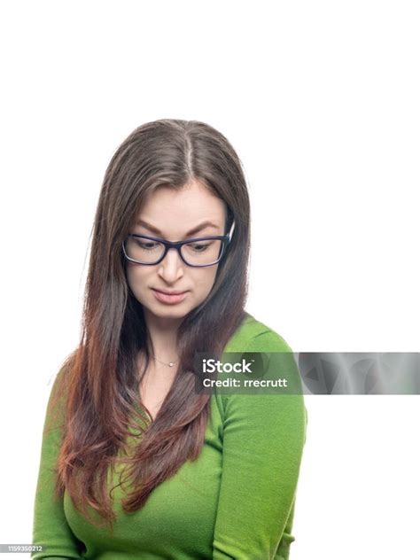 청녀 초상화 긴 고용 갈색 머리 여성 모델 안경과 녹색 블라우스 그녀의 얼굴에 회의적인 감정으로 내려다 보고 흰색 배경에 격리된 수직 이미지입니다 만족스럽지 않은 고객 개념
