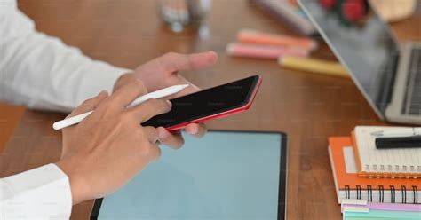 스타일러스 펜과 스마트폰을 들고 나무 작업 책상을 얹고 있는 흰색 빈 화면 컴퓨터 태블릿 앞에 앉아 있는 사업가 사진 Unsplash의 태국 이미지