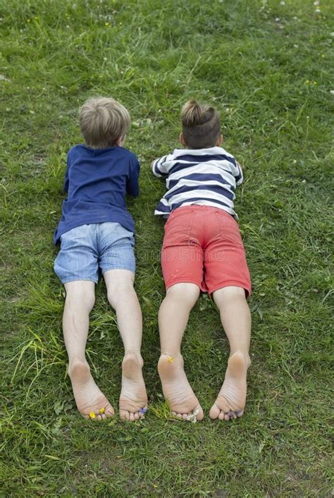 两个赤脚男孩躺在草地上的肚子上 库存照片 图片 包括有 感觉 概念 和谐 愉快 男朋友 朋友 355455700