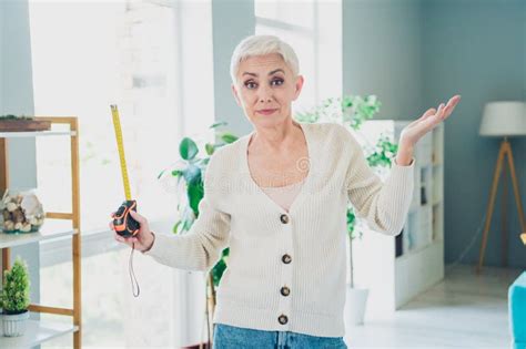 Photo Of Funny Retired Woman Hold Measuring Centimeter Tape Relocation New Apartment Home House