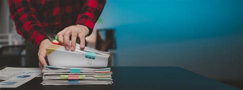 서류 더미가 쌓인 회사원인 그는 사무실에서 일하고 초과 근무를 하고 사무실 문서를 정리하는 신생 회사 직원입니다 중요한 문서 작업의 개념입니다 결심에 대한 스톡 사진 및