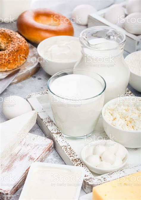 화이트 빈티지 나무 상자에서 신선한 유제품 테이블 배경 병 그리고 우유 크림 치즈와 계란의 그릇의 유리 신선한 구운된 베이글에 칼으로도 마를 라운드 구도에 대한 스톡 사진