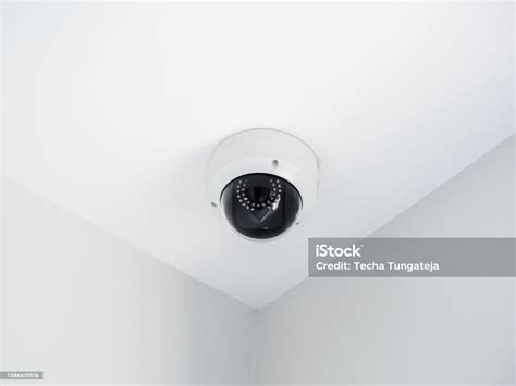 디지털 보안 눈 흰색 둥근 실내 Cctv 감시 카메라는 흰색 깨끗한 건물 내부의 방 구석에 천장에 보안을 모니터링합니다 돔