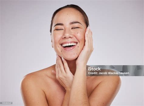 아름다움 스킨케어 그리고 스튜디오에 있는 여자의 얼굴은 광채를 위한 피부과 화장품에 대해 행복하다 회색 배경에 화장과 얼굴 셀프 케어에 대해 웃고 있는 피부에 손을 얹은