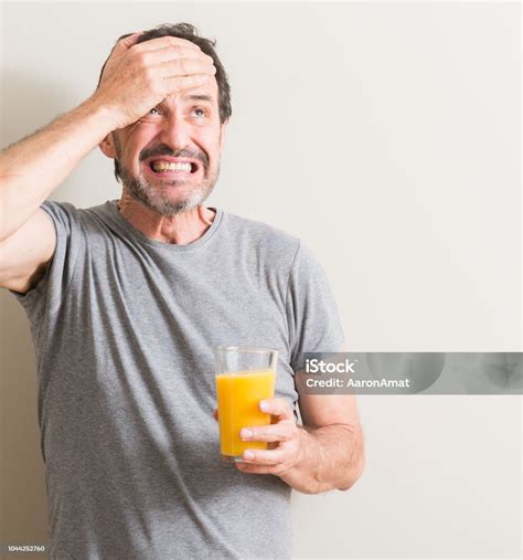 수석 남자 머리에 손으로 압박 하는 유리에 오렌지 주스를 마시는 충격 수치심과 깜짝 얼굴로 분노와 좌절 두려워 하 고 실수에 대 한 화가 감정에 대한 스톡 사진 및 기타