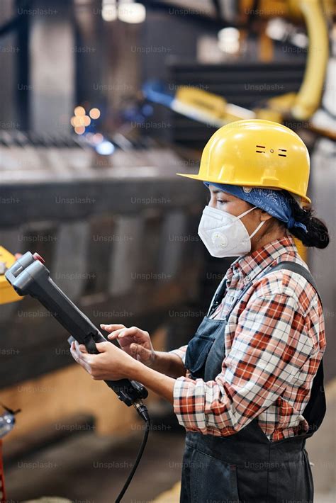 창고에서 산업 기계의 작업을 제어하기 위해 스위치 장치를 사용하는 공장의 현대 기술자의 측면도 사진 Unsplash의 제어 이미지