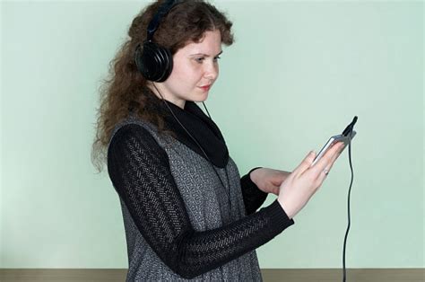 곱슬 머리를 가진 여성이 손에 들고 있는 디지털 태블릿을 주의 깊게 바라본다 가정 생활에 대한 스톡 사진 및 기타 이미지 가정 생활 곱슬 머리 긴 머리 Istock