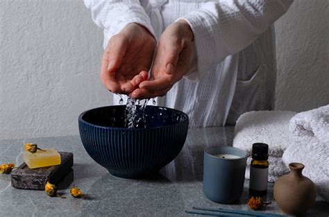 천연 스파 트리트먼트 목욕 가운을 입고 그릇에 물을 붓는 여성 양초 아로마 오일 유기농 비누와 꽃 회색 표면에 흰색 수건 건강관리와 의술에 대한 스톡 사진 및 기타 이미지