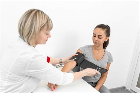 전문 여성 의사는 병실에서 젊은 여성 환자 손에 압력을 측정하기위한 장치에 넣어 2명에 대한 스톡 사진 및 기타 이미지 2명