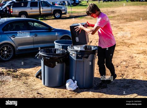 A Man Sorting Waste Into Three Recycling Bins At An Event In Burnet United States Stock Photo
