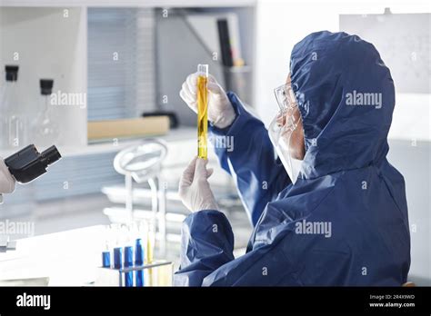 Side View Of Scientist Wearing Protective Suit Working With Hazardous Materials In Laboratory