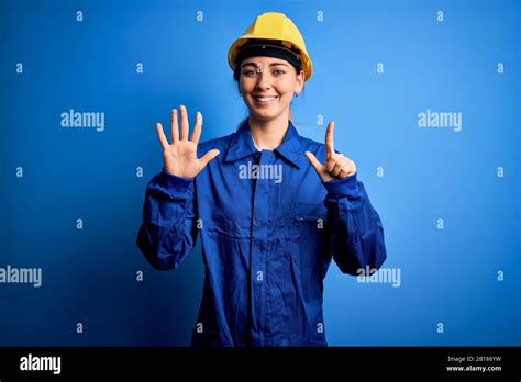 Young Beautiful Worker Woman With Blue Eyes Wearing Security Helmet And