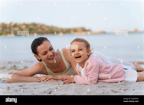 Gl Ckliche Mutter Mit Tochter Am Strand Liegen Stockfotografie Alamy