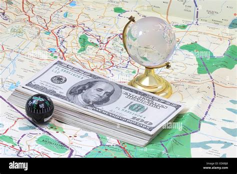 A Few Dollars Lying On The Map With Glass Globe And Compass Stock