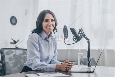欢乐的电台主持人在麦克风附近工作的地方坐着时高清图片下载 正版图片506098829 摄图网