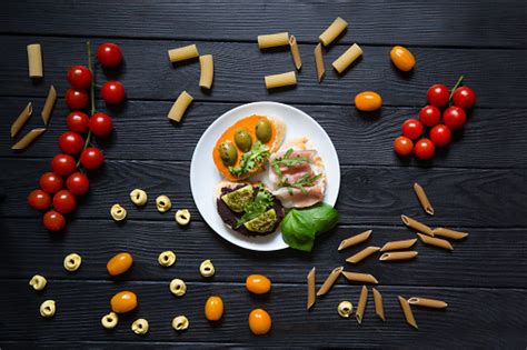 파 르 마 이탈리아 햄 Rucola 올리브 파스타 올리브 부식 질과 검은 나무 배경에 흰색 접시에 바 질 맛 있는