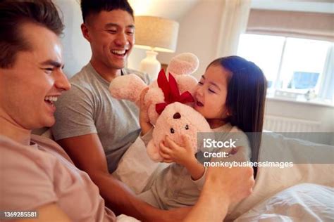 가족과 두 아빠와 함께 침대에 침대 에 집에서 재생 게임 와 딸 과 그녀의 부드러운 장난감 2 3 살에 대한 스톡 사진 및 기타 이미지 2 3 살 3 명 30 34세