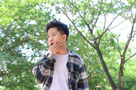 公园里穿着休闲衬衫的年轻亚洲男子