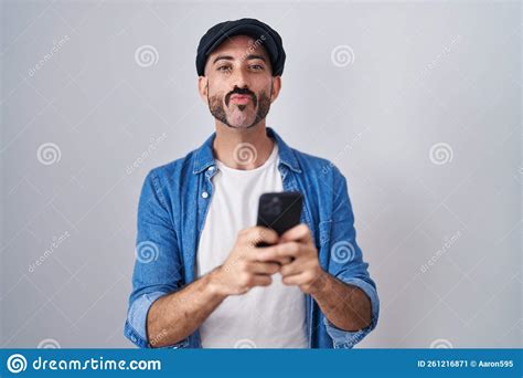 Hispanic Man With Beard Using Smartphone Typing Message Looking At The