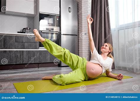 Beautiful Pregnant Woman With Naked Tummy Lifting One Leg Up Doing