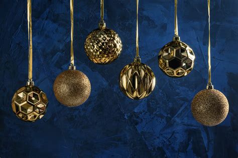 텍스처와 장식 퍼 티와 어두운 파란색 배경에 리본에 매달려 황금 크리스마스 공 크리스마스 복사 공간 구성입니다 텍스트에 대 한 장소를 가진 축제 레이아웃입니다 0명에 대한