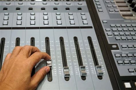 Sound Engineer Working On Mixing Console Closeup Of Hands Doing Adjust A Fader Stock Image