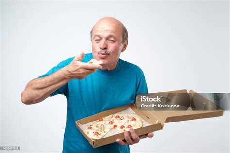 피자 한 조각을 먹고 성숙한 유럽 남자의 초상화 그의 손에 그 음식의 상자를 보유 하고있다 스튜디오 촬영 사람들에 대한 스톡 사진 및 기타 이미지 Istock